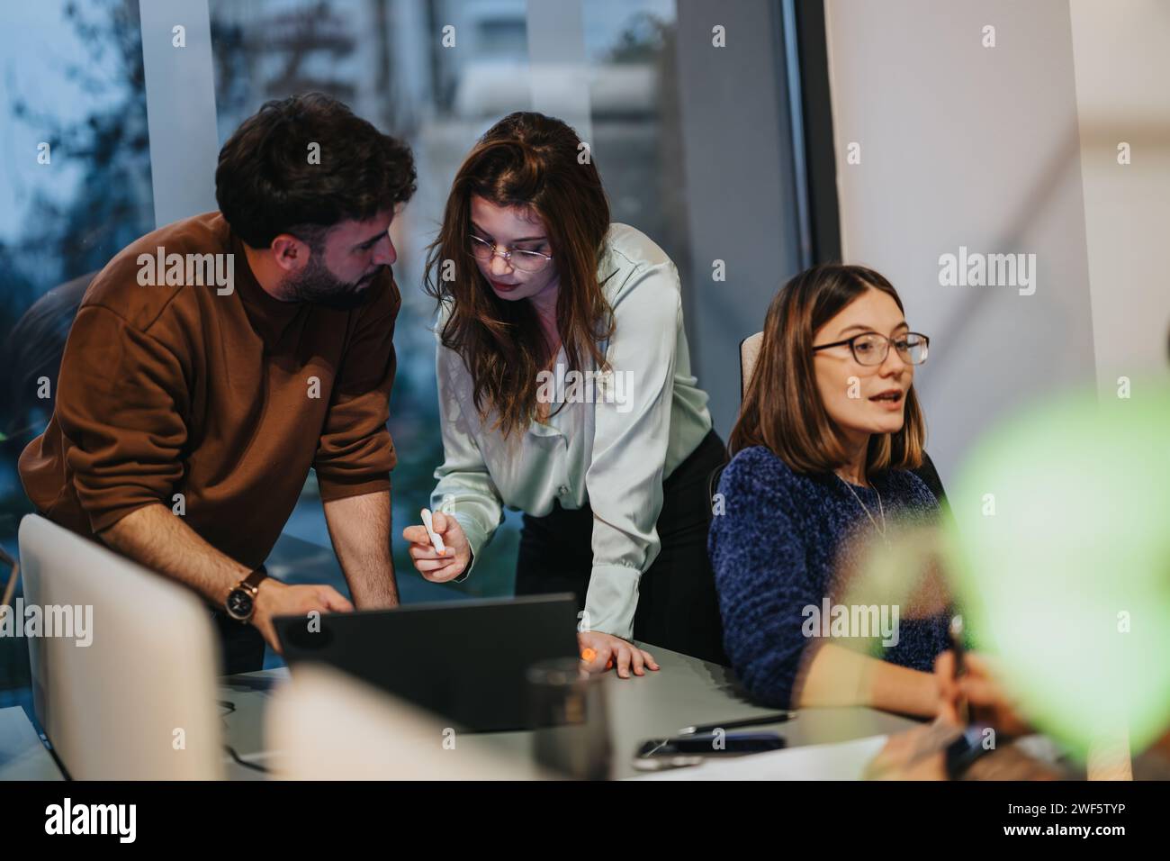Focused group of multiethnic business colleagues collaborating and ...