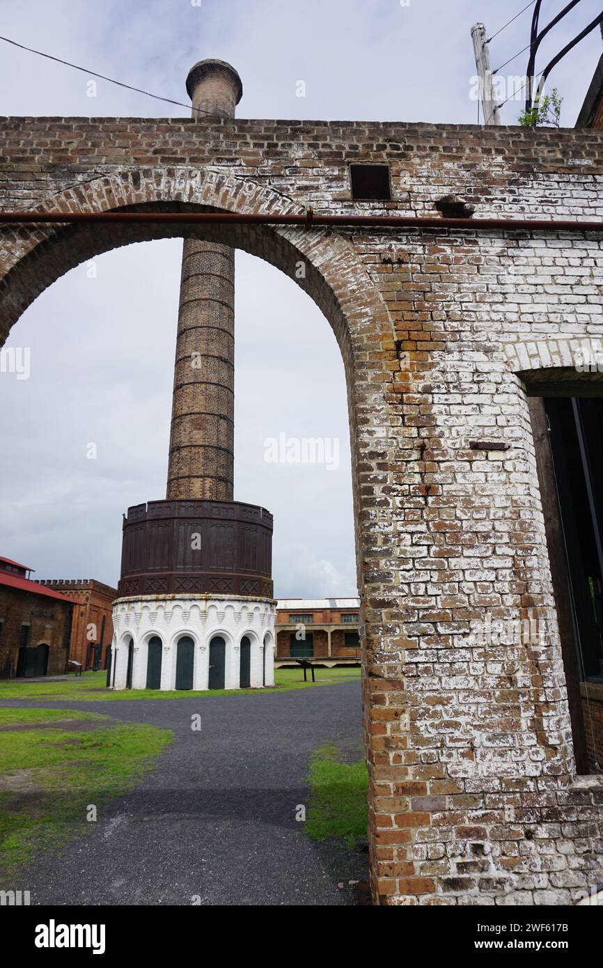 Historic Brick Smokestack Stands Tall Beyond a Weathered Archway on a ...