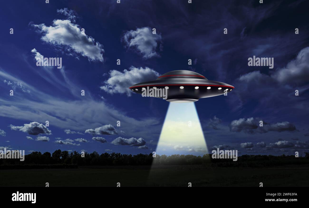 UFO. Alien spaceship emitting light beam over meadow Stock Photo - Alamy