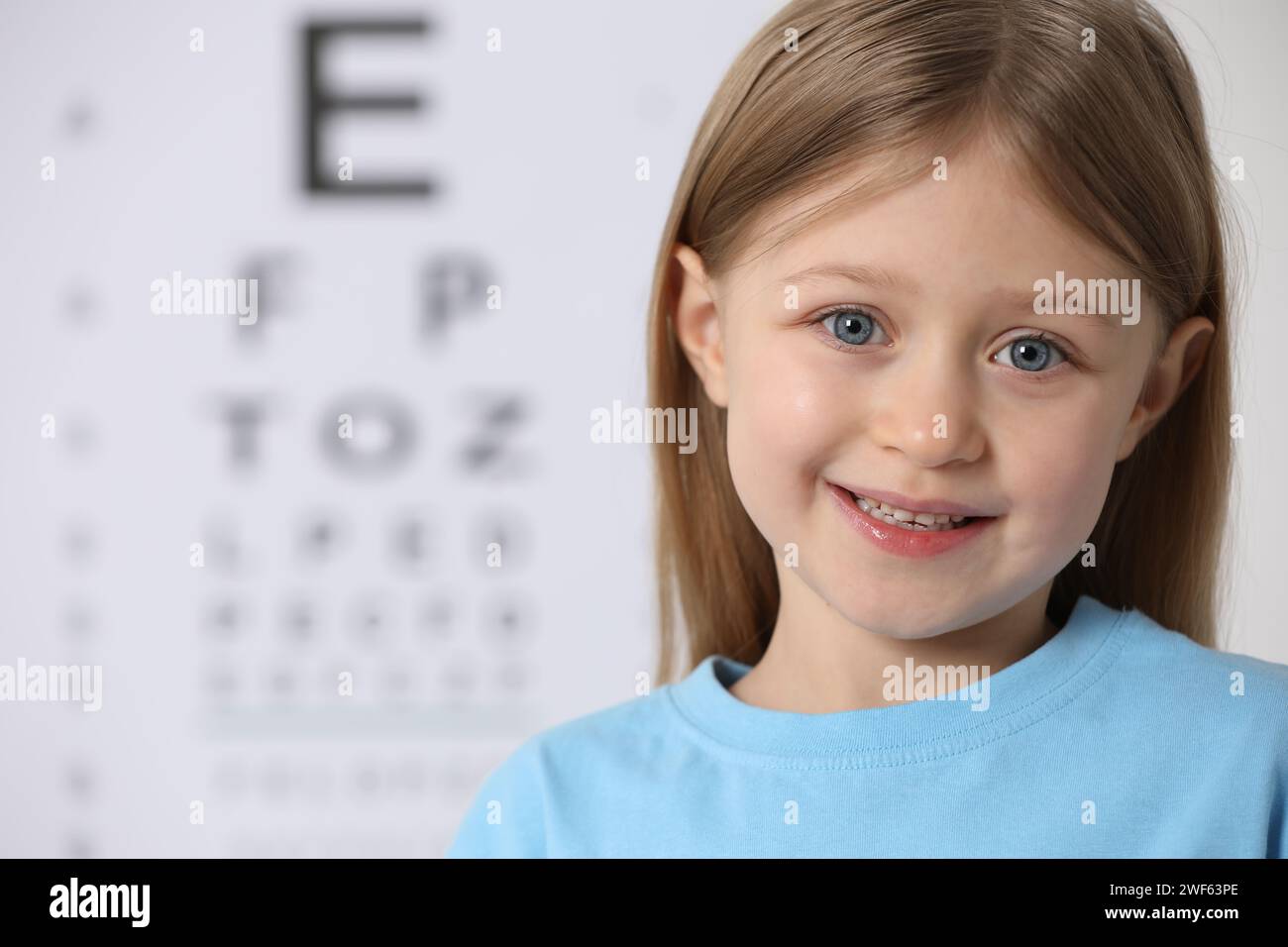 Cute little girl against vision test chart Stock Photo - Alamy