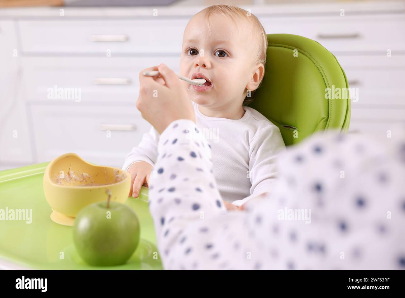 Mother feeding her cute little baby with healthy food at home Stock ...