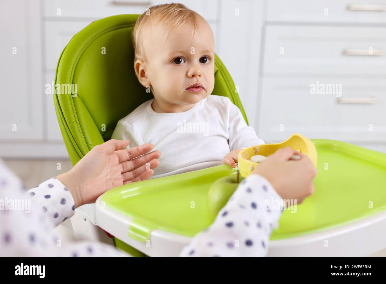Mother feeding her cute little baby with healthy food at home Stock ...