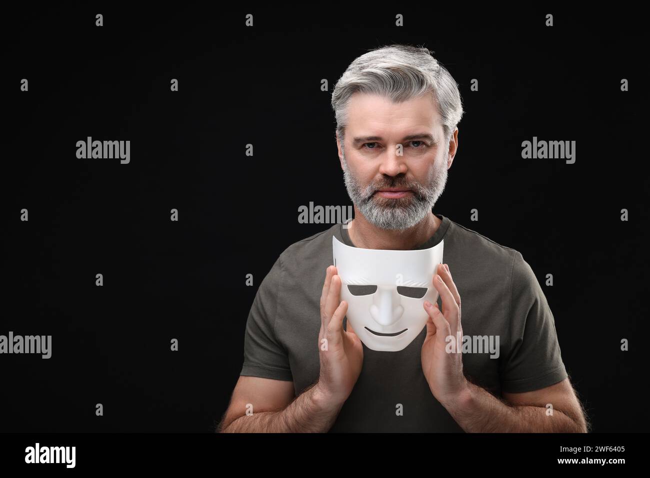 Multiple personality concept. Man with mask on black background. Space ...