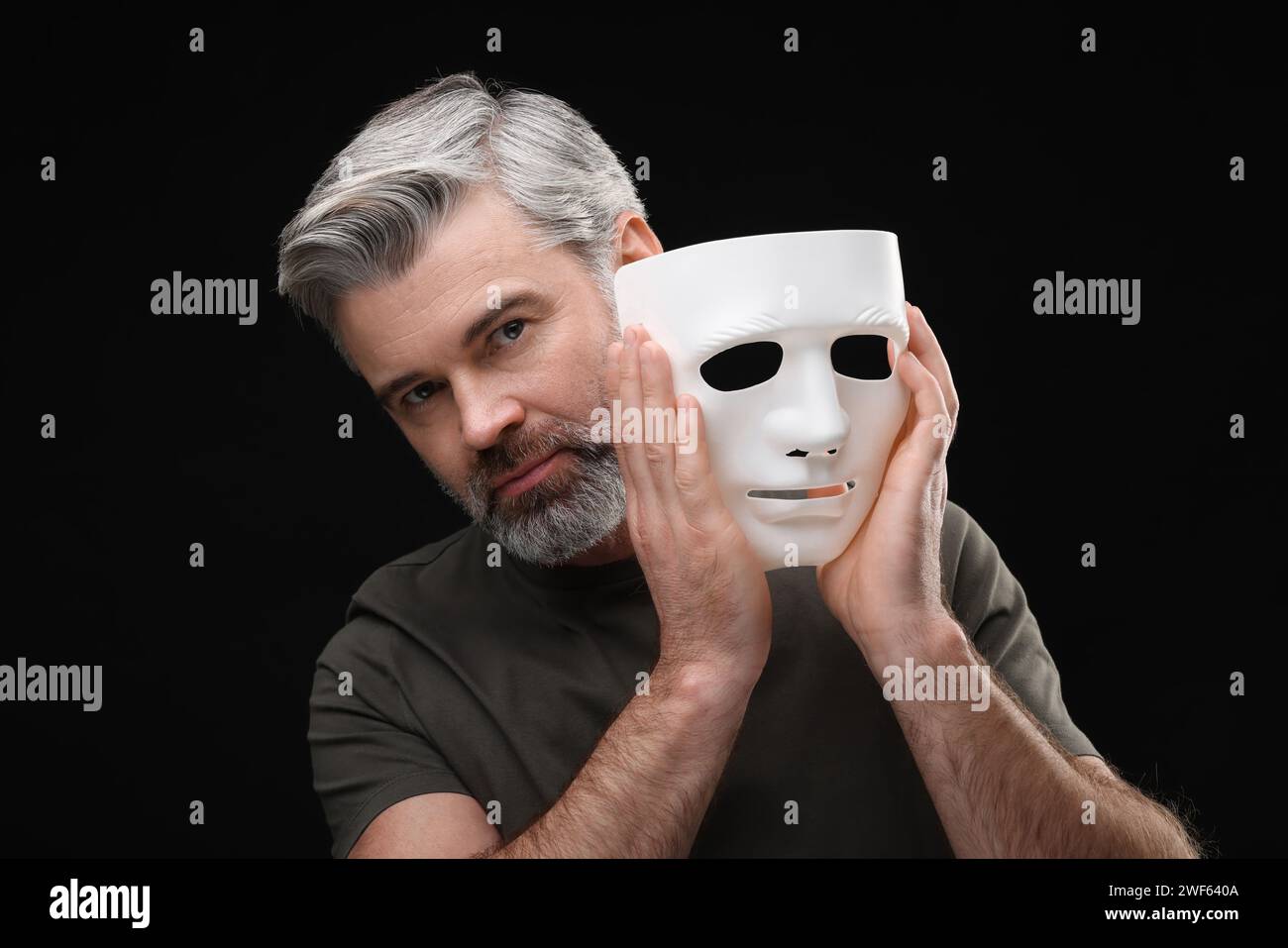 Multiple personality concept. Man with mask on black background Stock ...