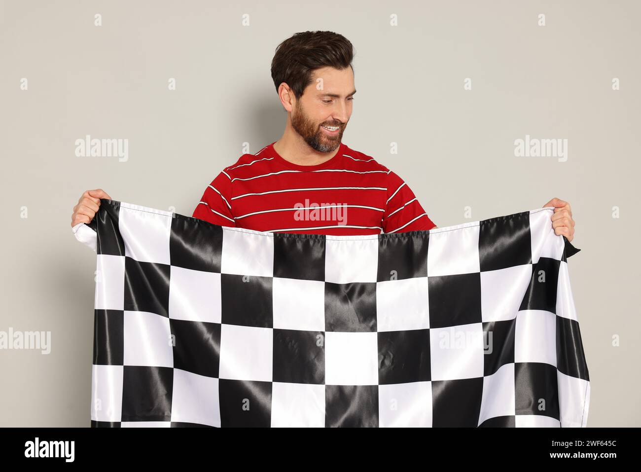 Man with checkered flag on white background Stock Photo - Alamy