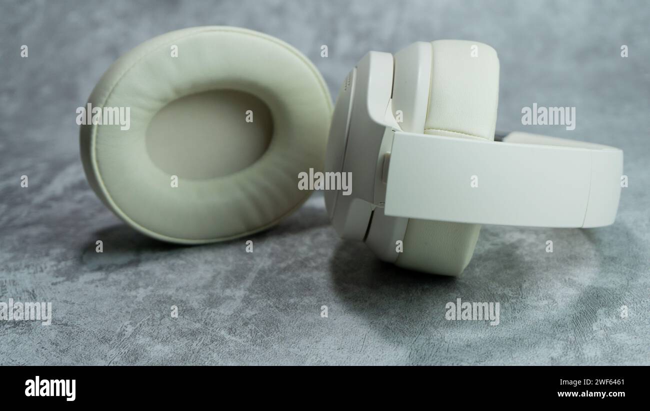 White headphones on a gray table with concrete texture Stock Photo - Alamy