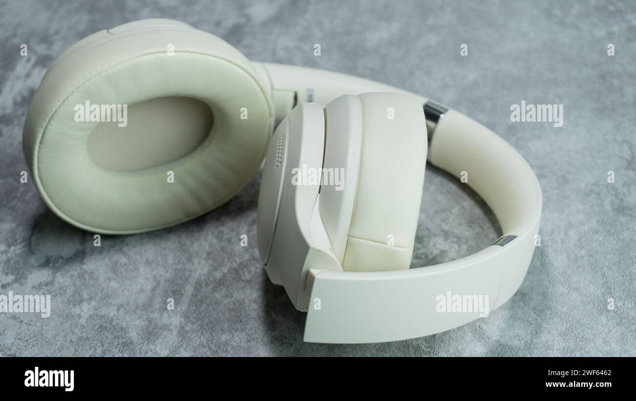 White headphones on a gray table with concrete texture Stock Photo - Alamy
