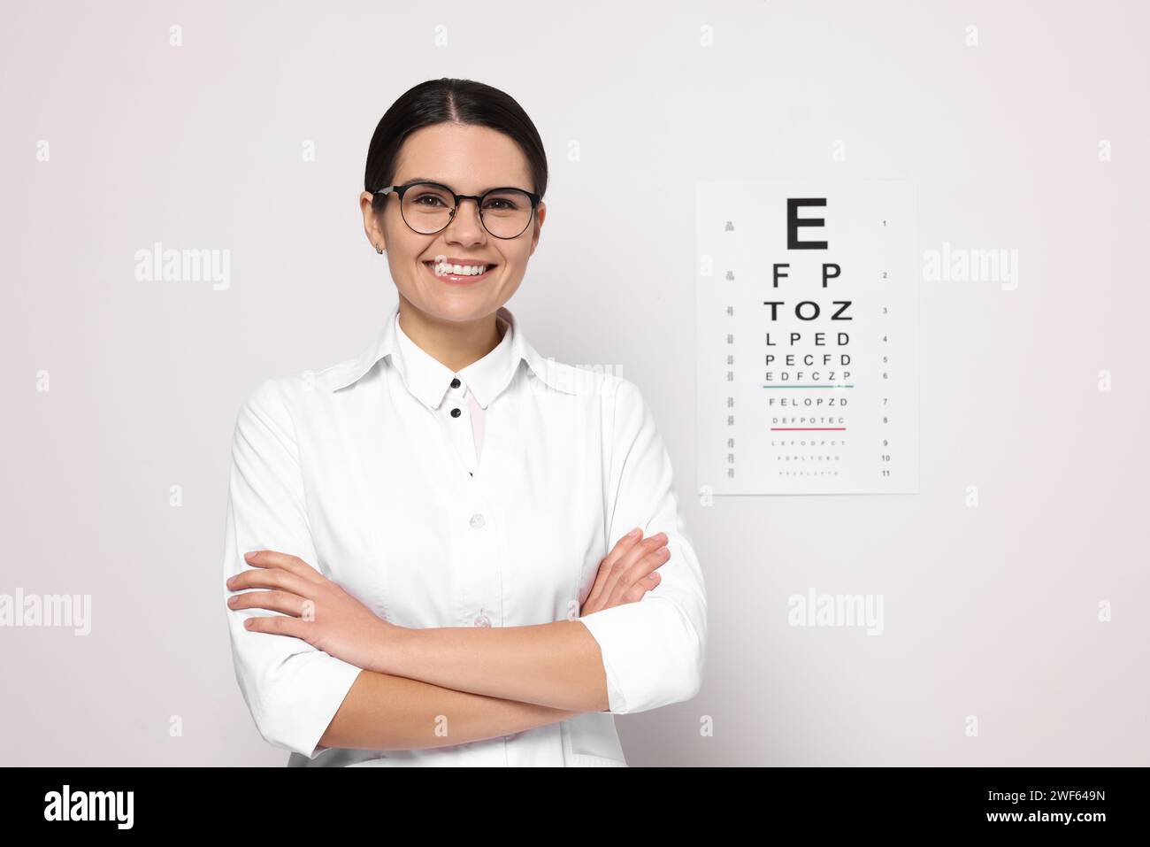 Ophthalmologist near vision test chart on white wall Stock Photo - Alamy