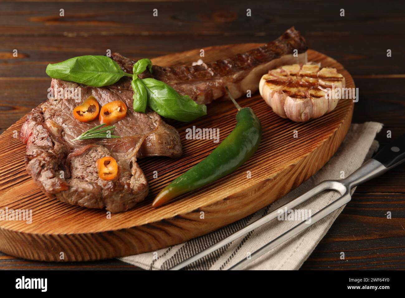 Delicious fried beef meat with garlic and chili pepper on table Stock ...