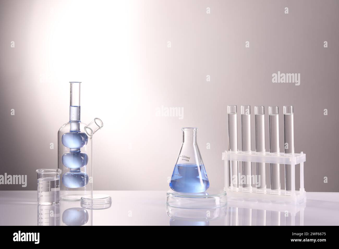 Laboratory analysis. Different glassware on table against light ...