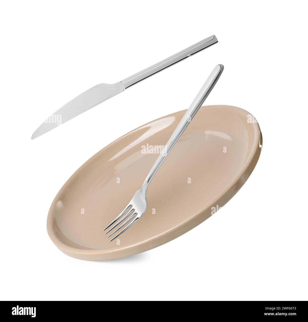 Clean plate, fork and knife falling on white background Stock Photo - Alamy