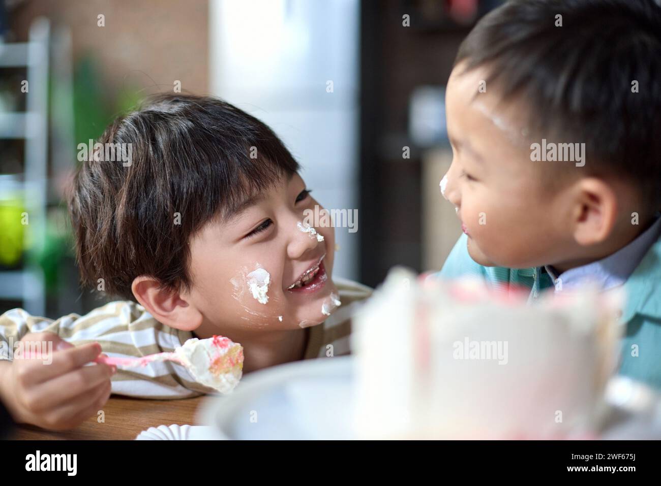 Two brothers eating birthday cake together Stock Photo - Alamy