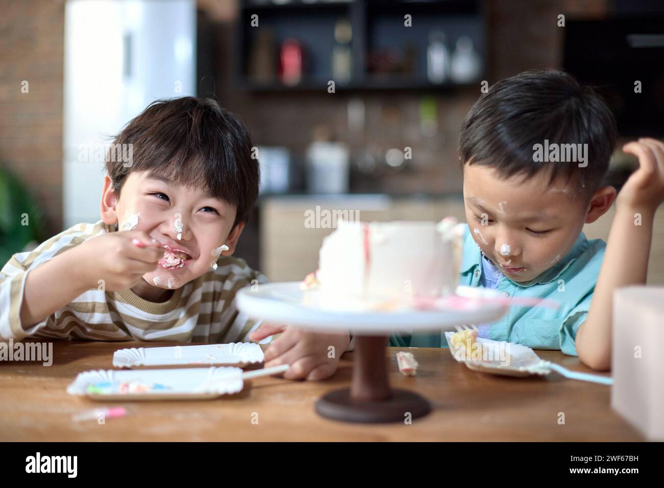 Two brothers eating birthday cake together Stock Photo - Alamy