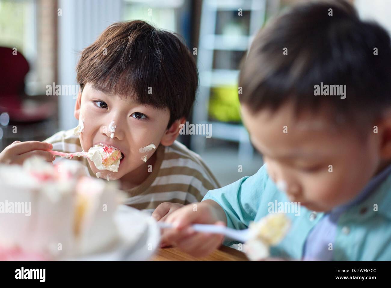 Two brothers eating birthday cake together Stock Photo - Alamy