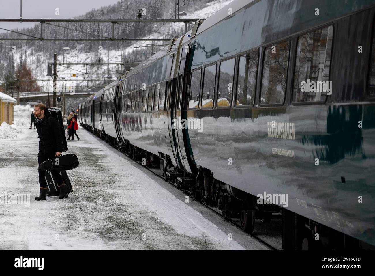 Several passengers are seen walking along the platforms of the Ål train ...