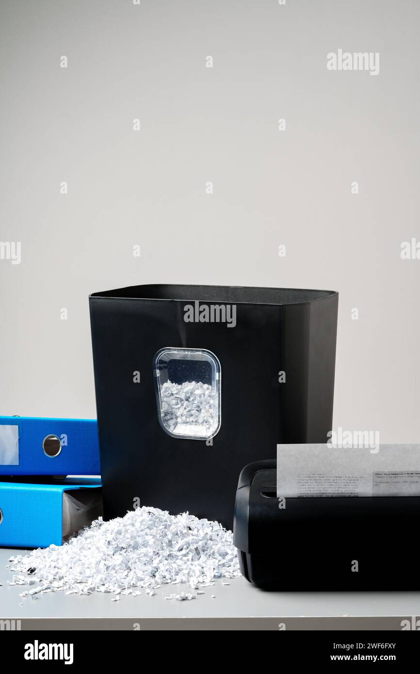 Office paper shredder on table against gray background Stock Photo - Alamy