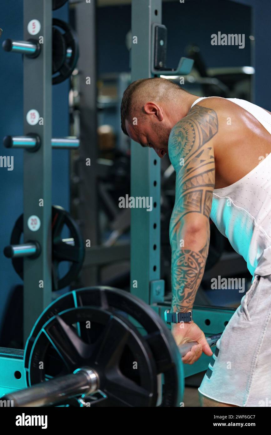 Man bodybuilder in white shirt training in a gym Stock Photo - Alamy
