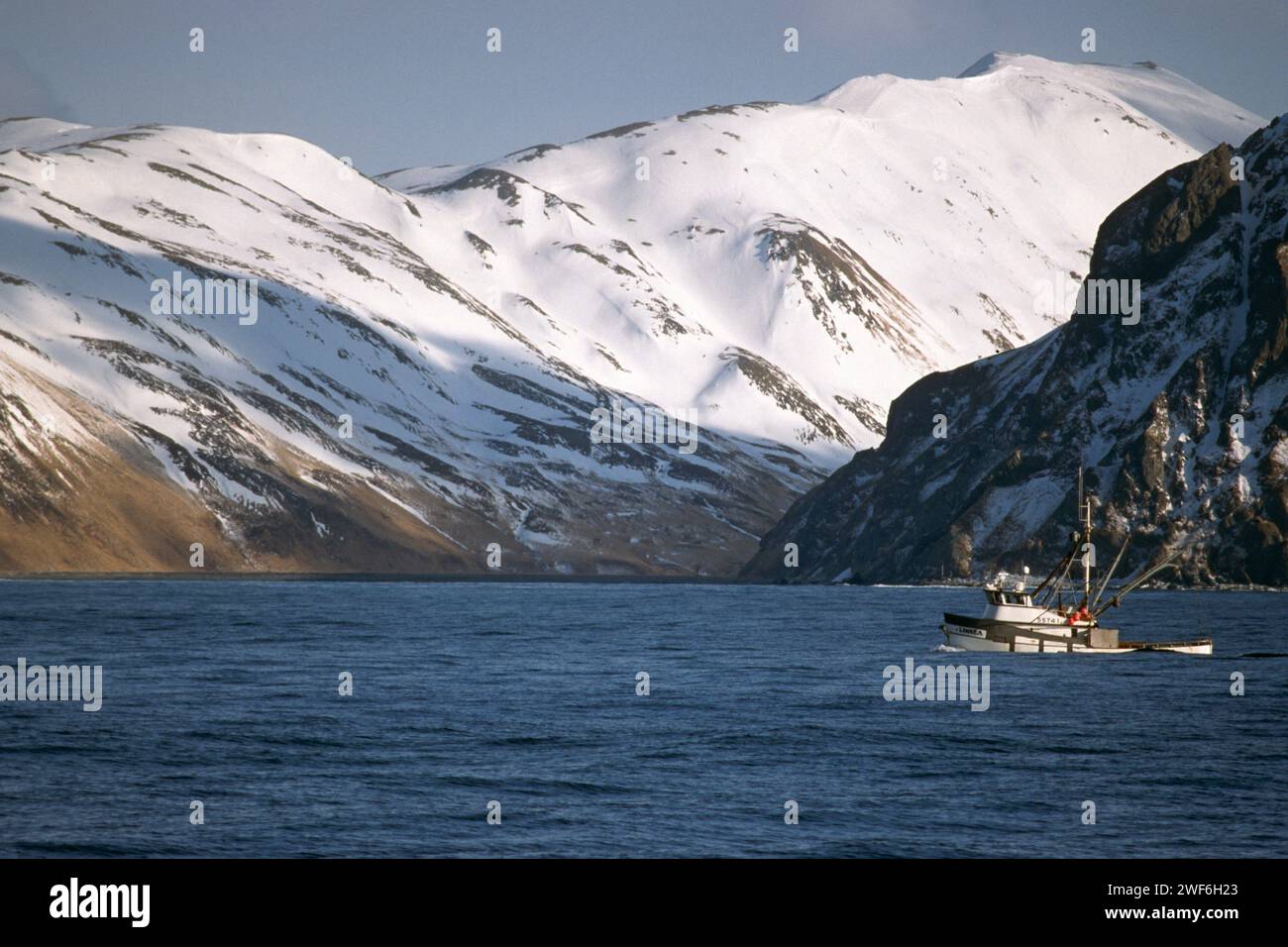 commercial fishing boat in the Bering sea of Alaska with snow covered ...