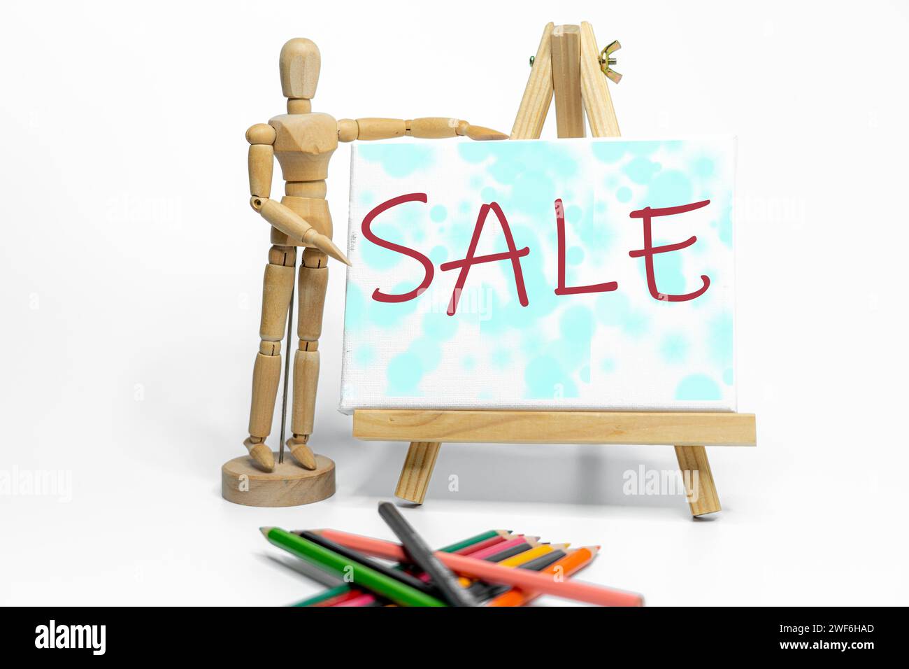Mannequin drawing a SALE on easel; isolated on white background ...