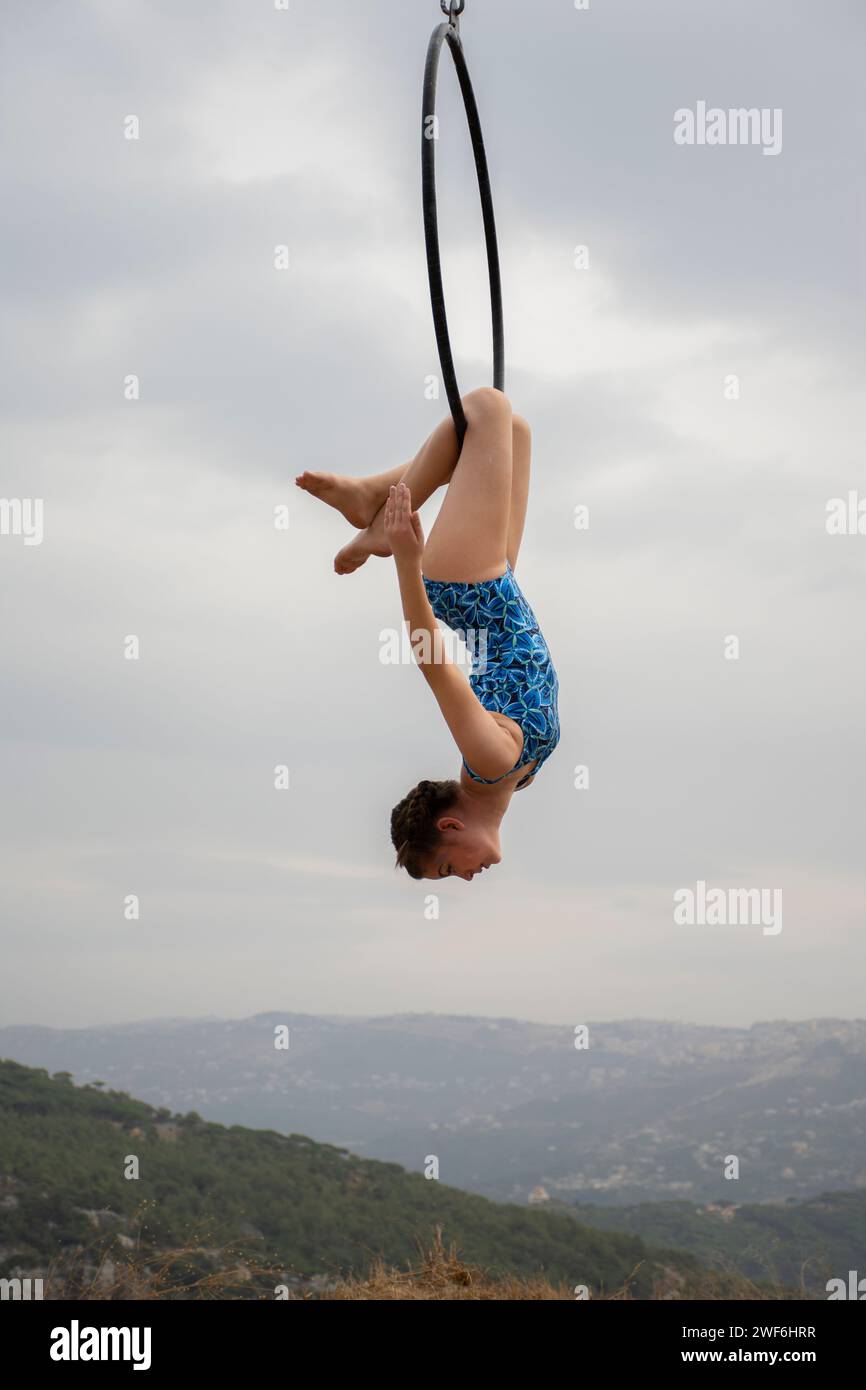 Little female gymnast performing on aerial hoop outdoors Stock Photo ...