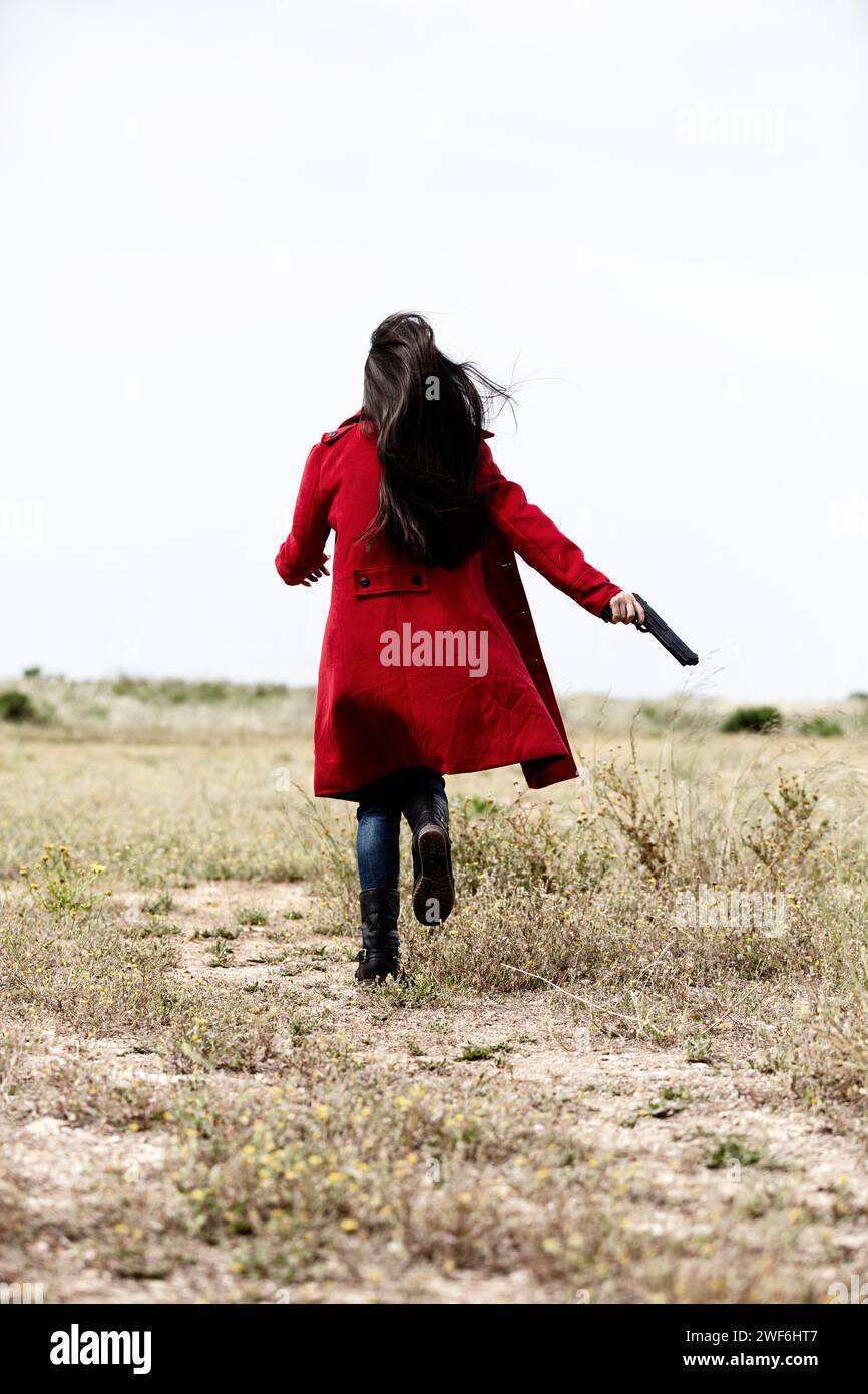Woman with gun behind back hi-res stock photography and images - Alamy
