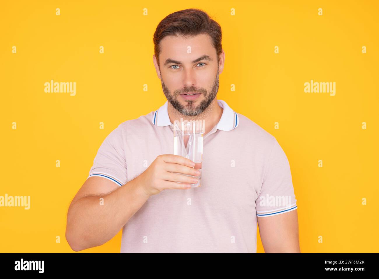Guy drinking water isolated on studio background. Man enjoy pure ...