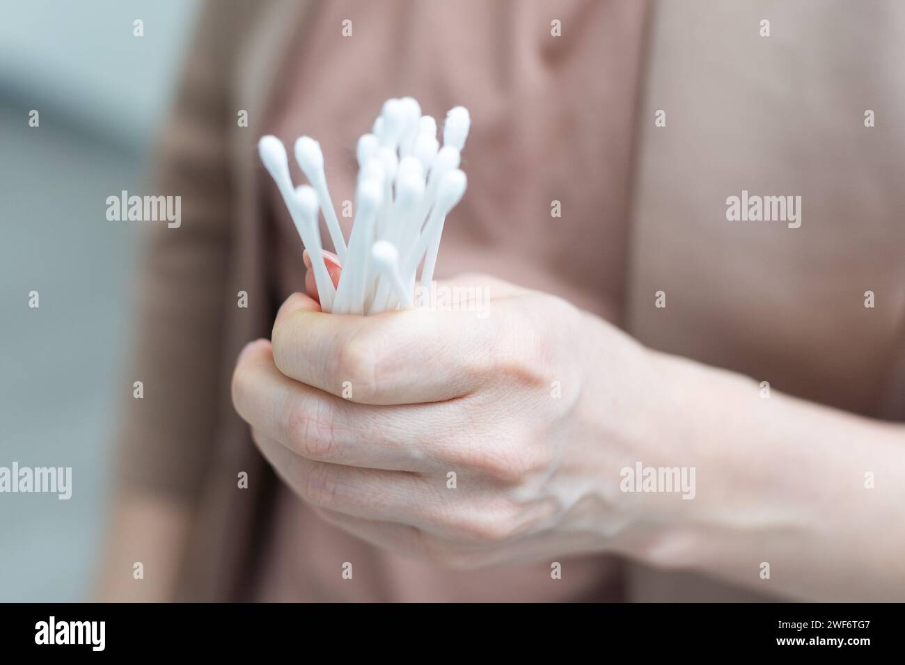 Cotton buds in hand isolated on white background Stock Photo - Alamy