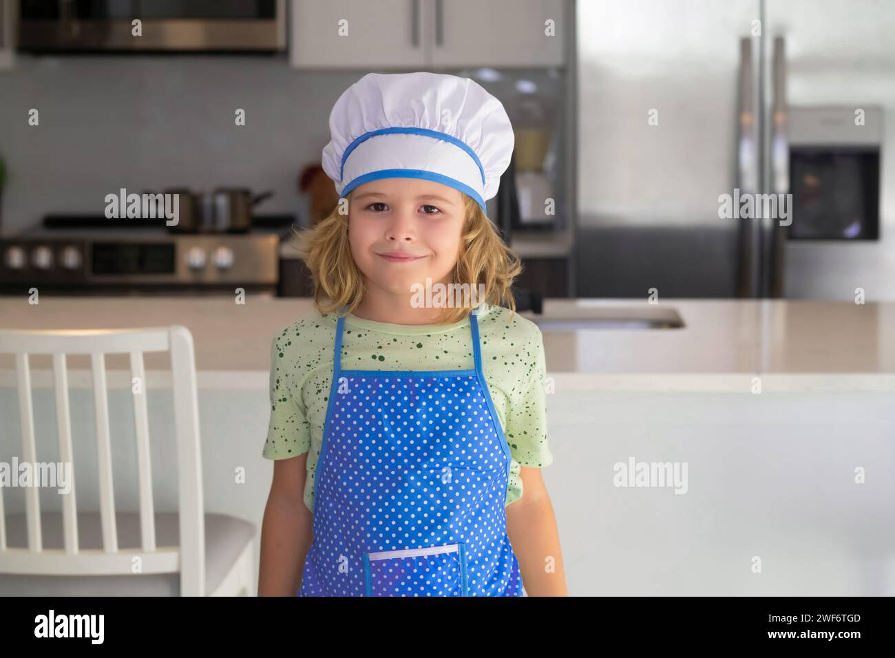 Children cooking in the kitchen. Funny kid chef cook cookery at kitchen ...