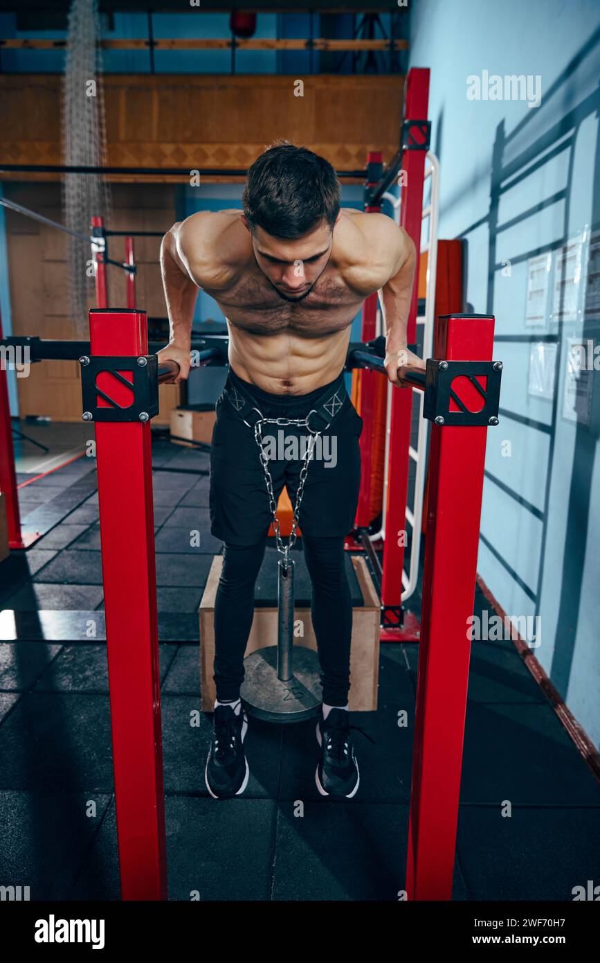 Fit young guy with muscular body training, doing dips exercises on ...