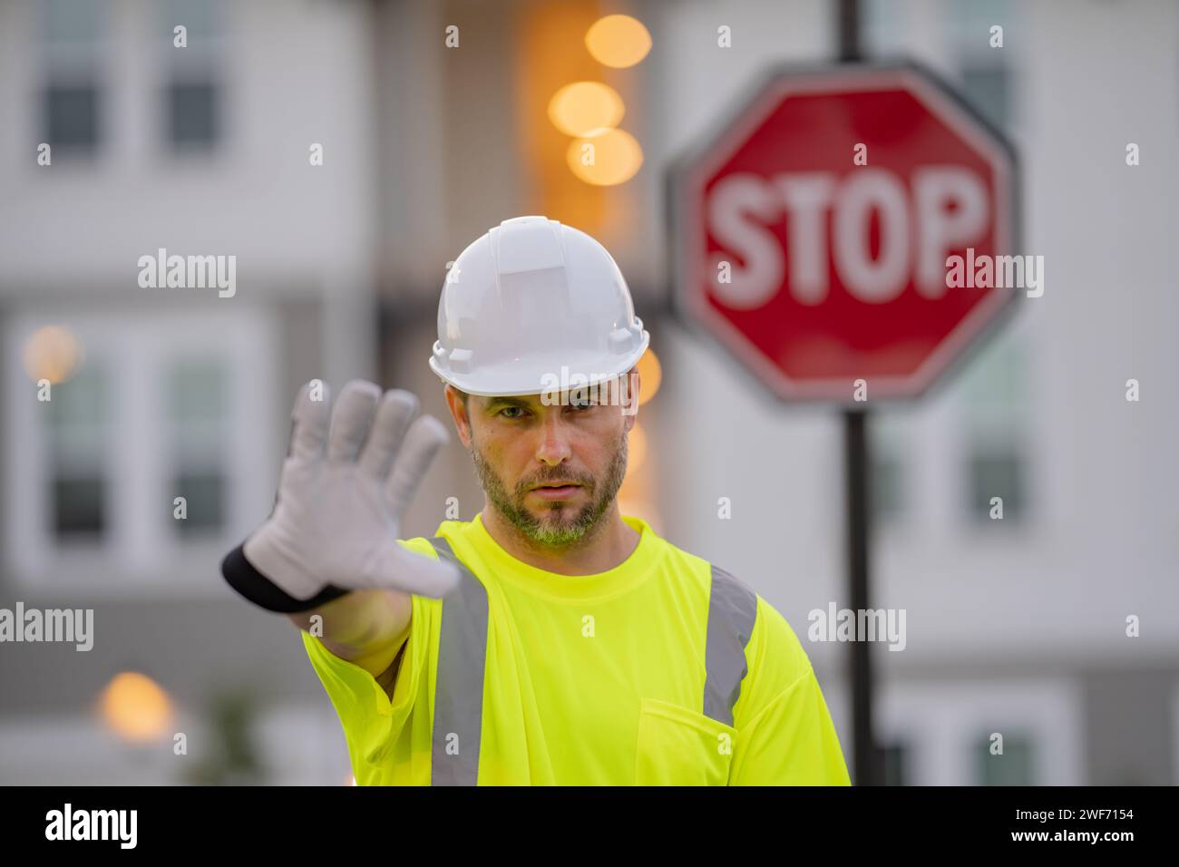 Serious engineer with stop road sign. Builder with stop gesture, no ...