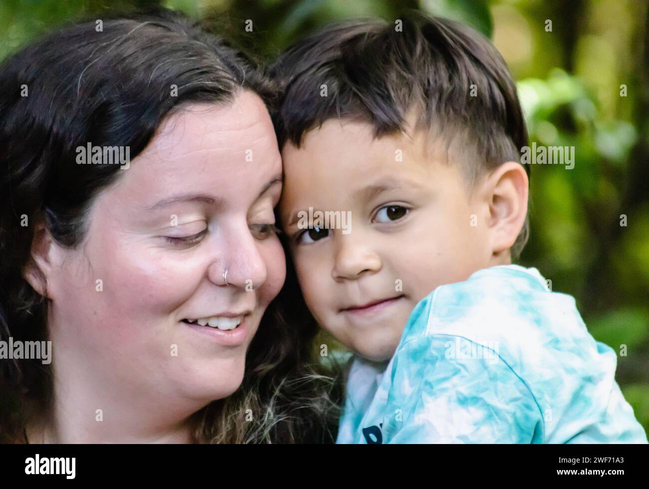 a close up image of a young Maori boy posing for a photograph with his ...