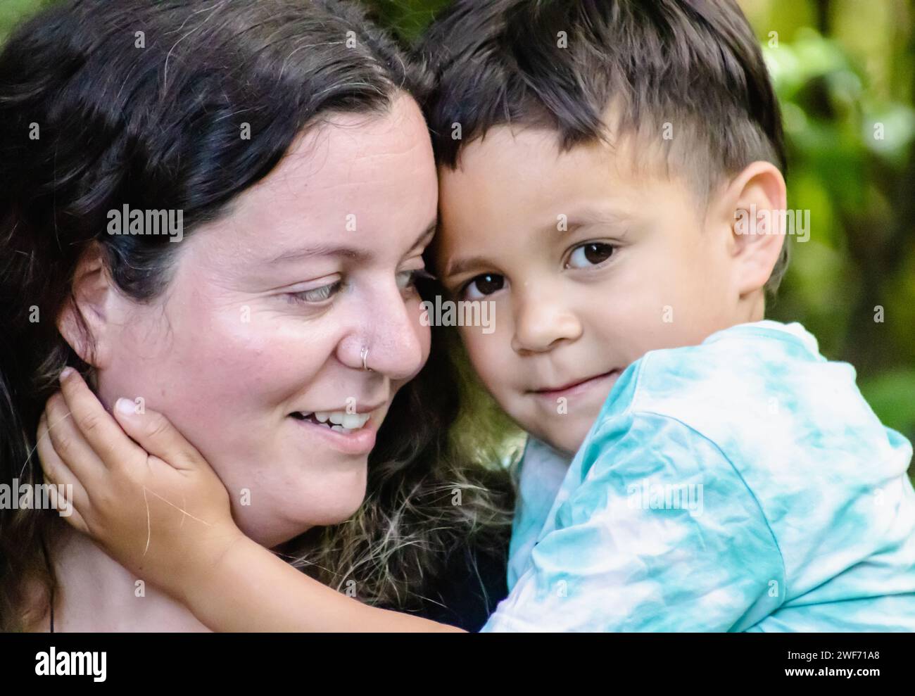 a close up image of a young Maori boy posing for a photograph with his ...