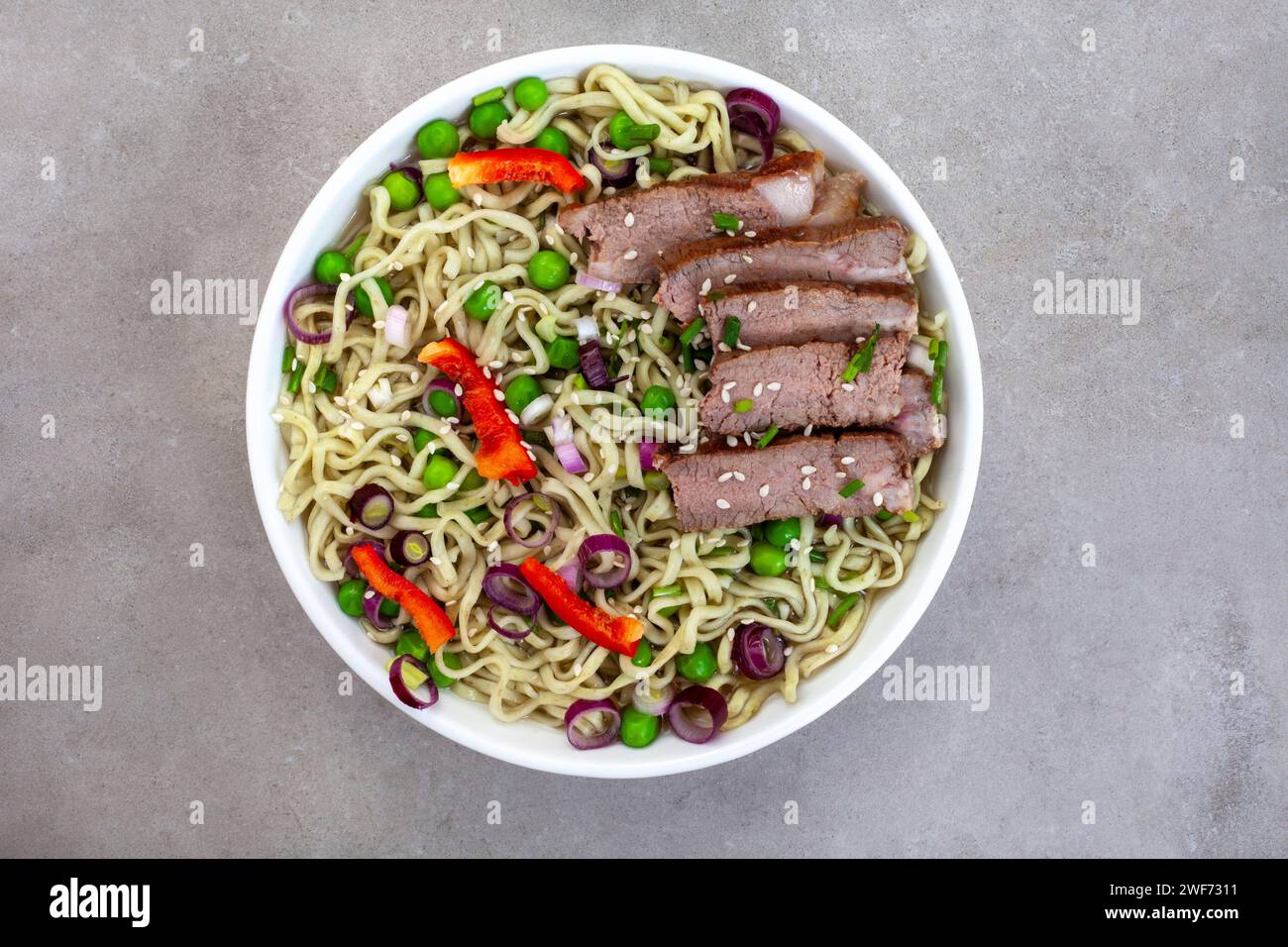 Spinach and kale Ramen noodles with spring onion, peas and sliced beef ...