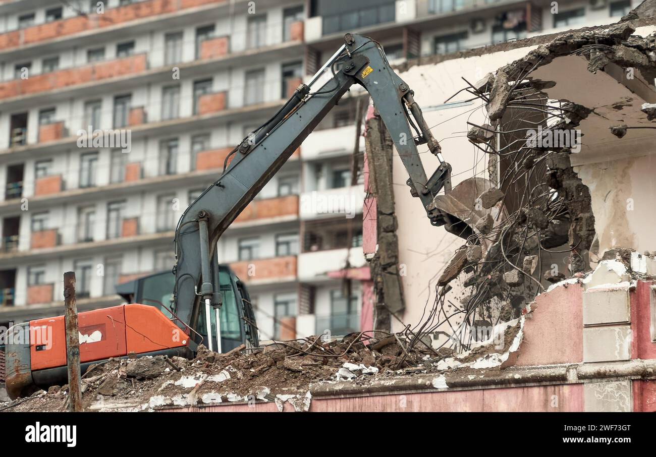 Excavator demolish or remove old ruined building in rainy day. Old ...