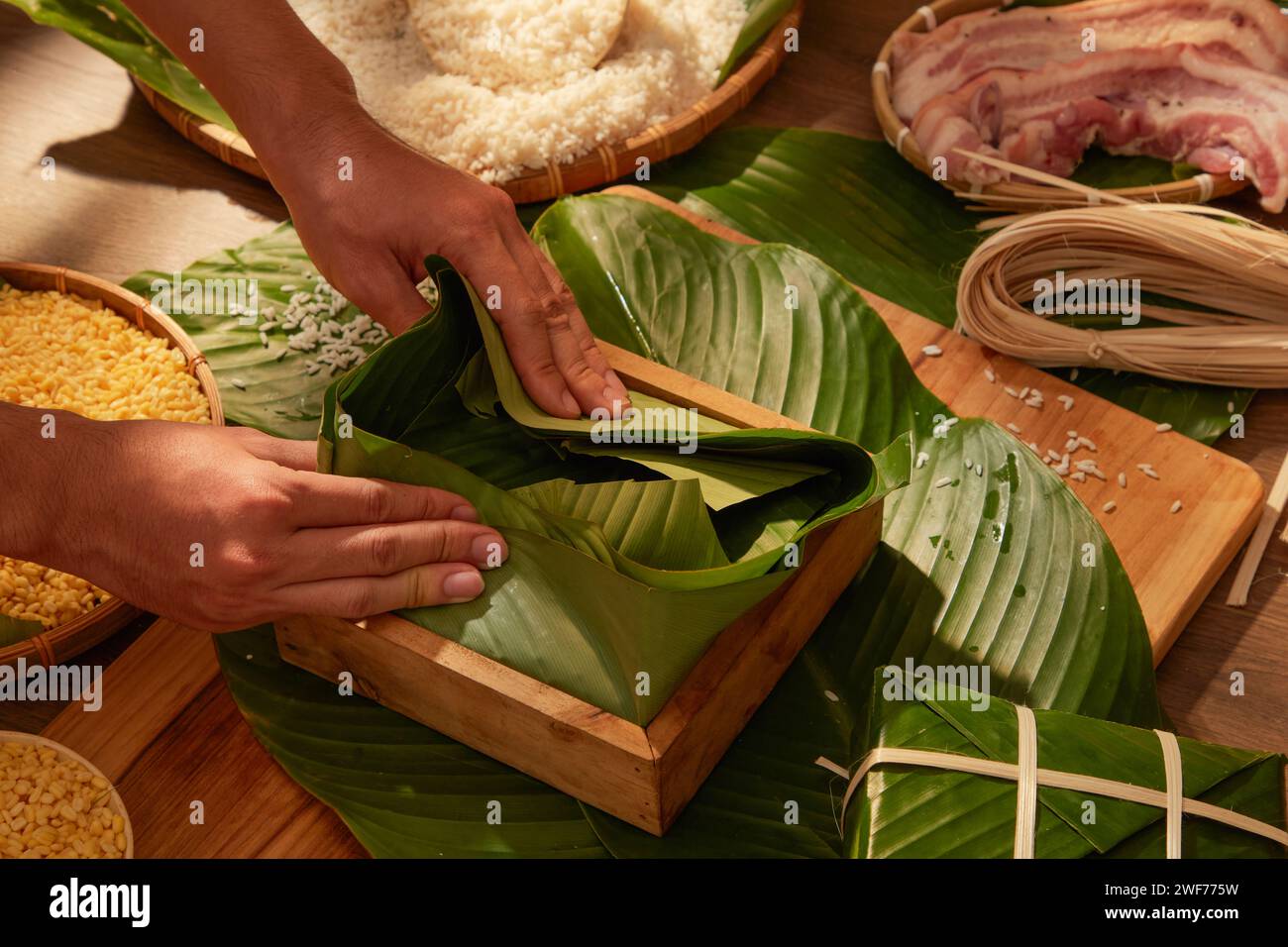 Front view of chef making Chung cake (sticky rice cake) with pork rice ...