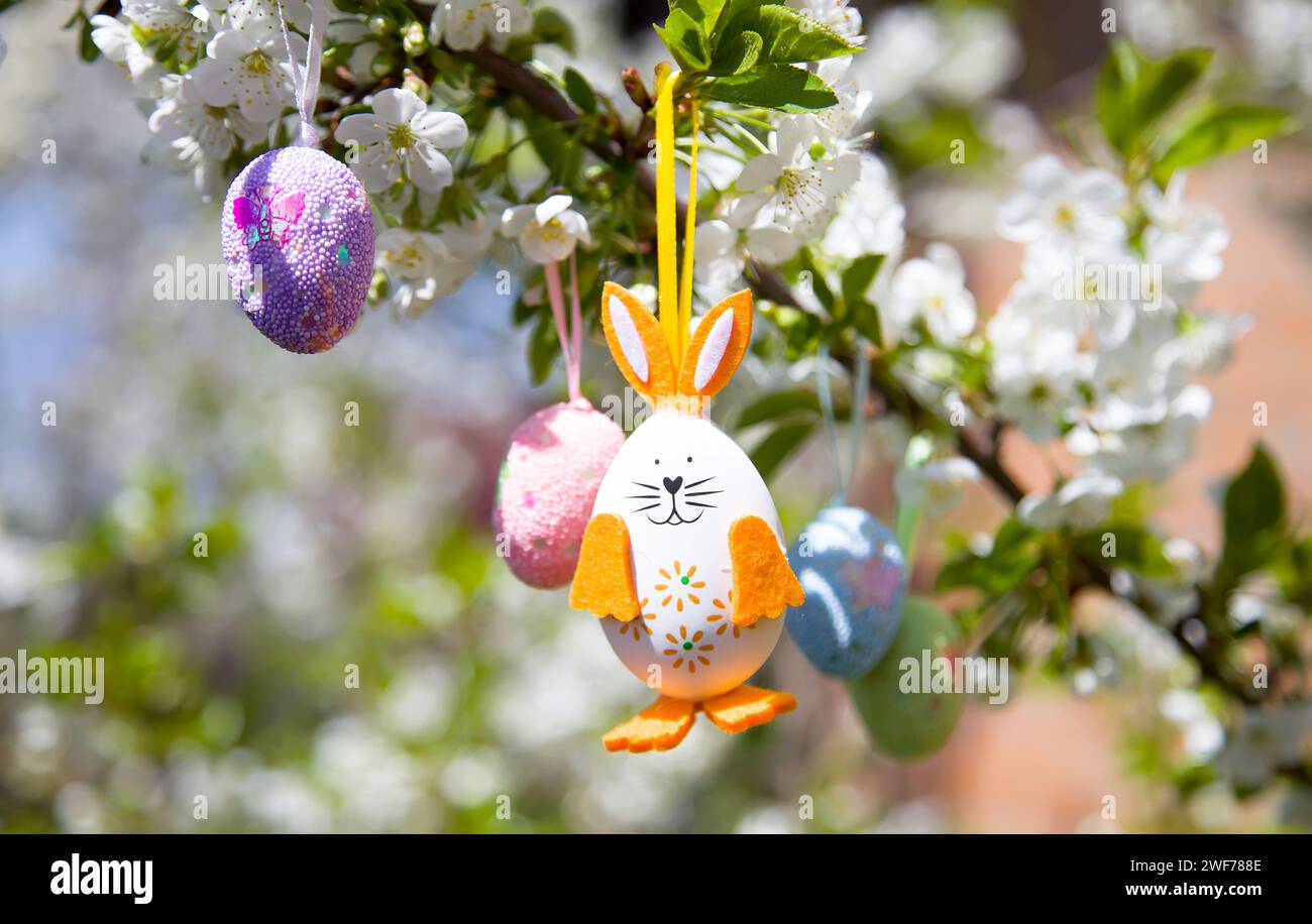 decorative easter eggs and rabbit hanging on flowering tree branch ...