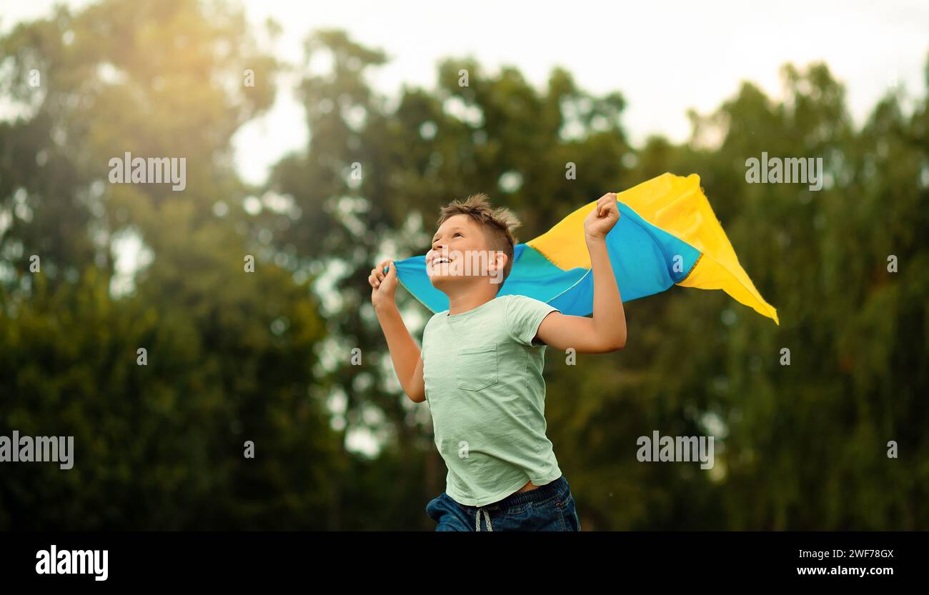 Happy ukrainian boy running with wawing yellow and blue national flag ...