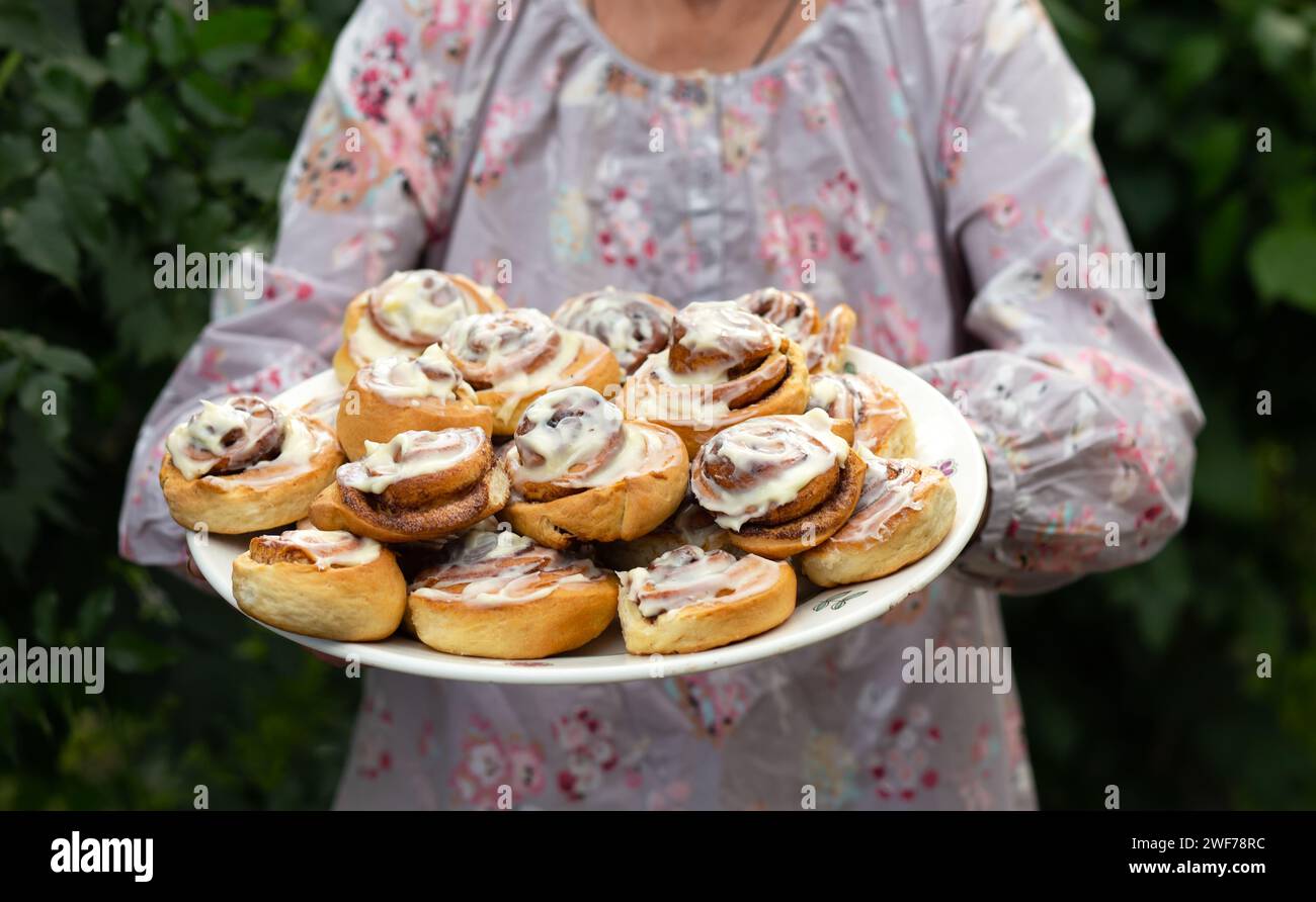 Platter of buns in the hands of a happy gray-haired grandmotherhappy ...