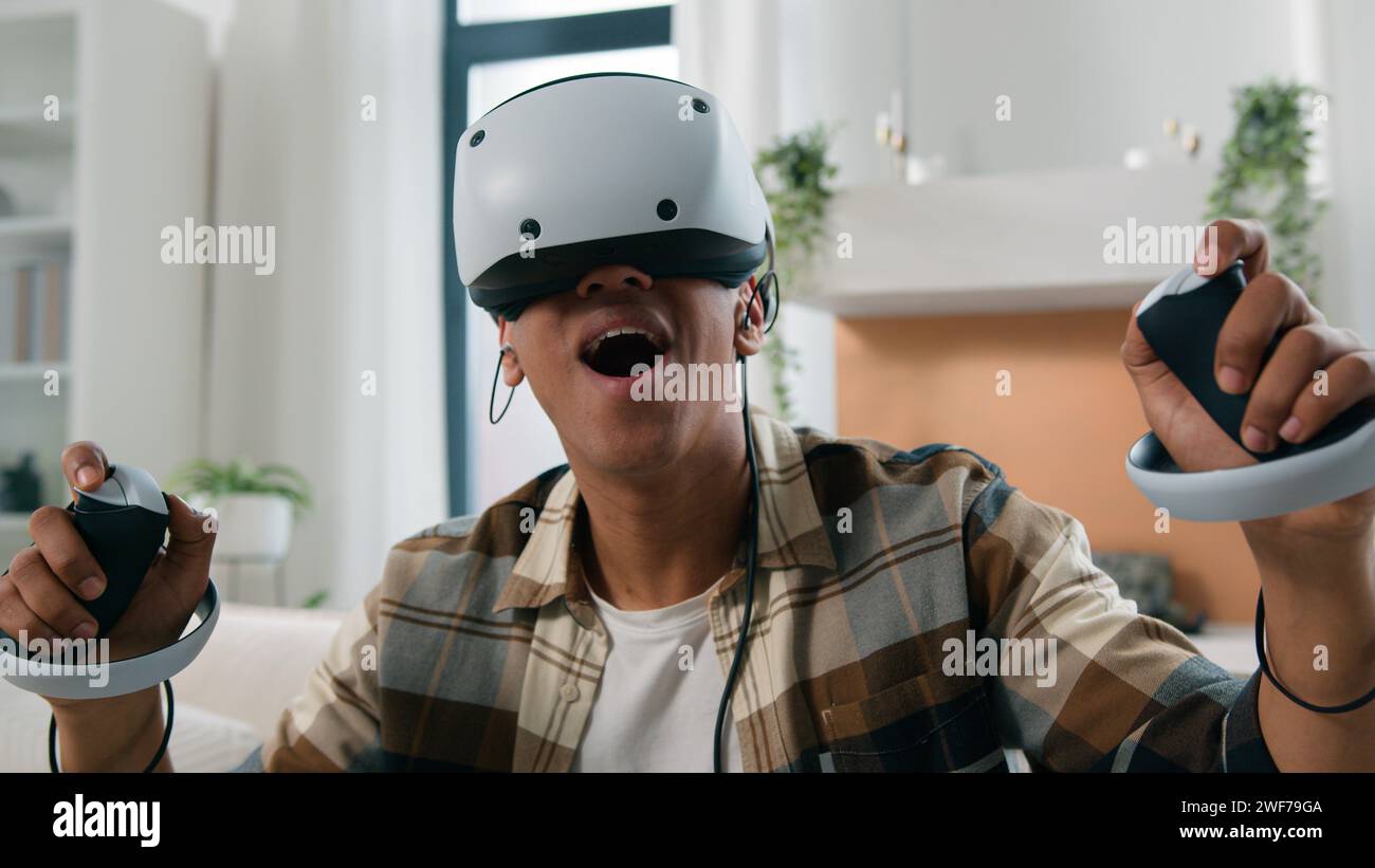 African American man exploring virtual reality experience at home 3d video game wonder amazed ...