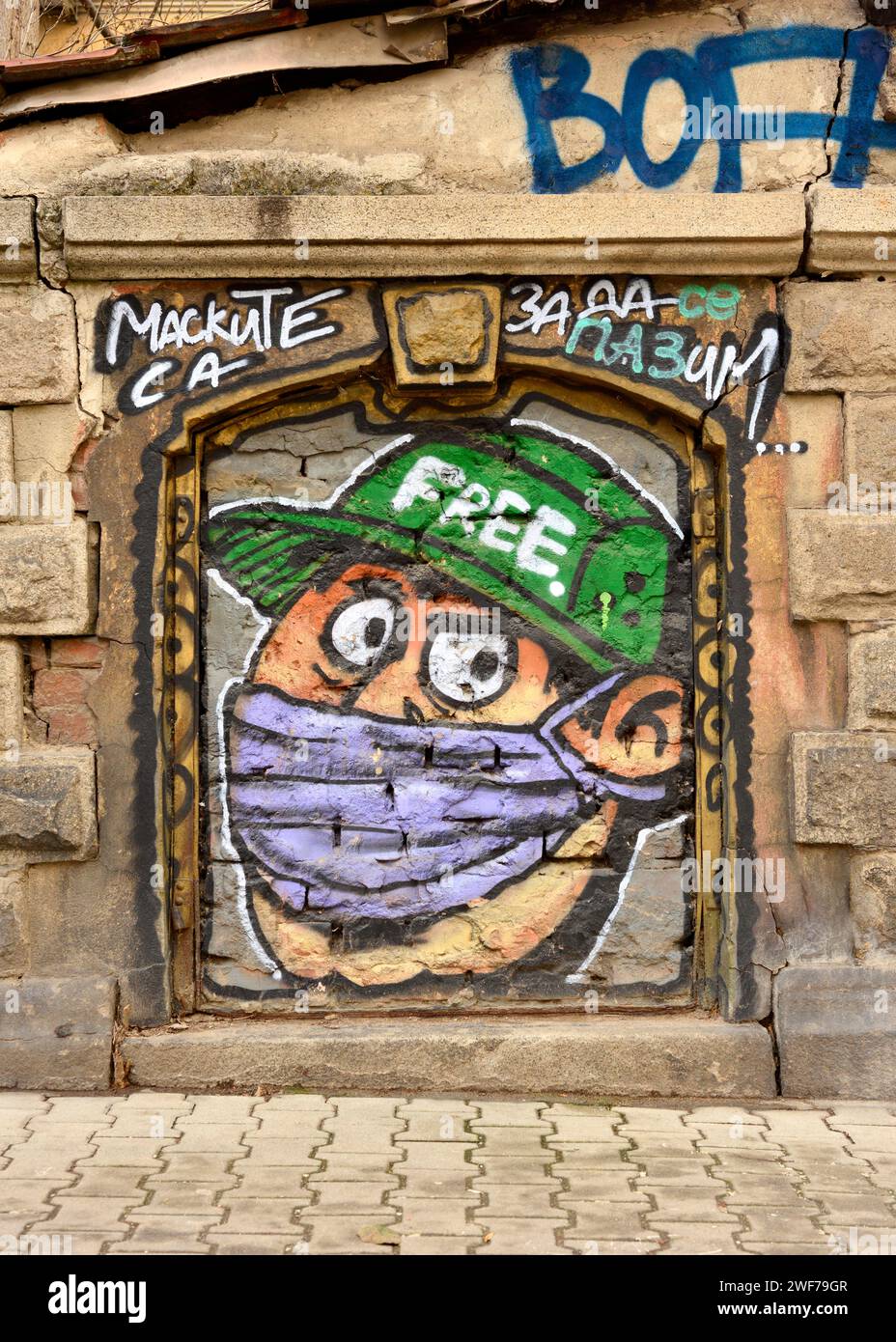 Boy with face mask graffiti street art with Cyrillic text reading Masks ...