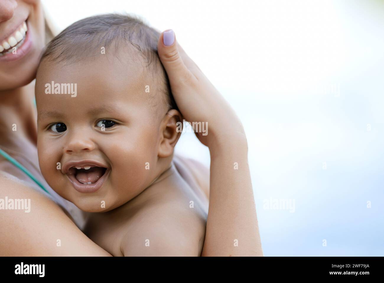 Close up portrait of mother hugging multiracial baby. Mom hug Biracial child. Closeup face of ...