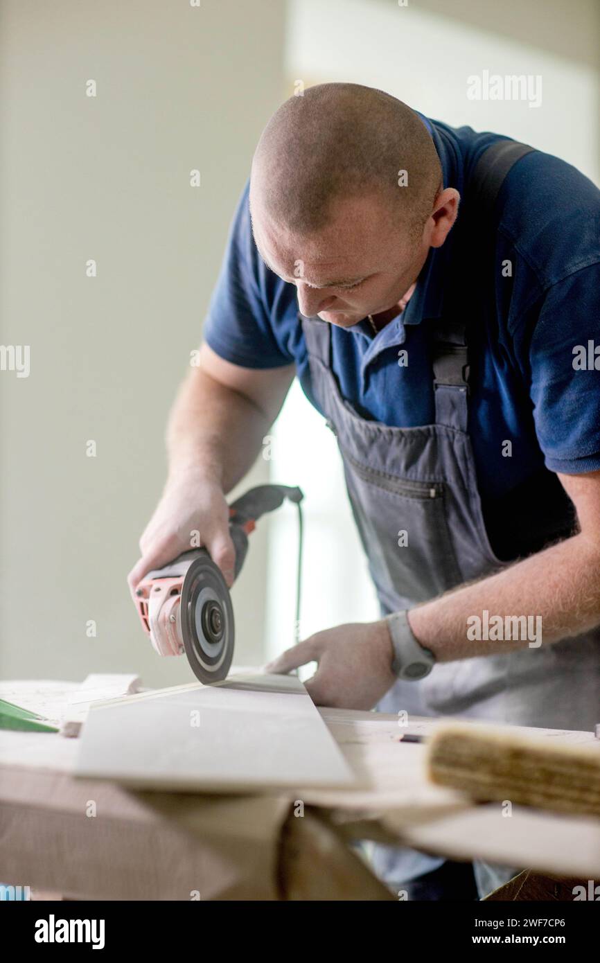 Professional tiler cutting tile with angle grinder. Construction ...