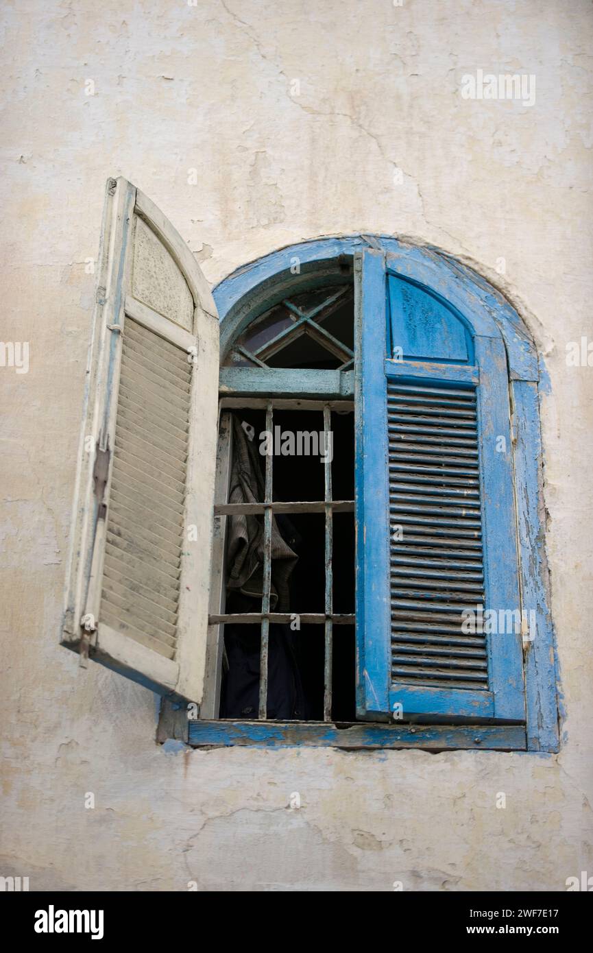 A faded blue shutter opens a window to the street Stock Photo - Alamy