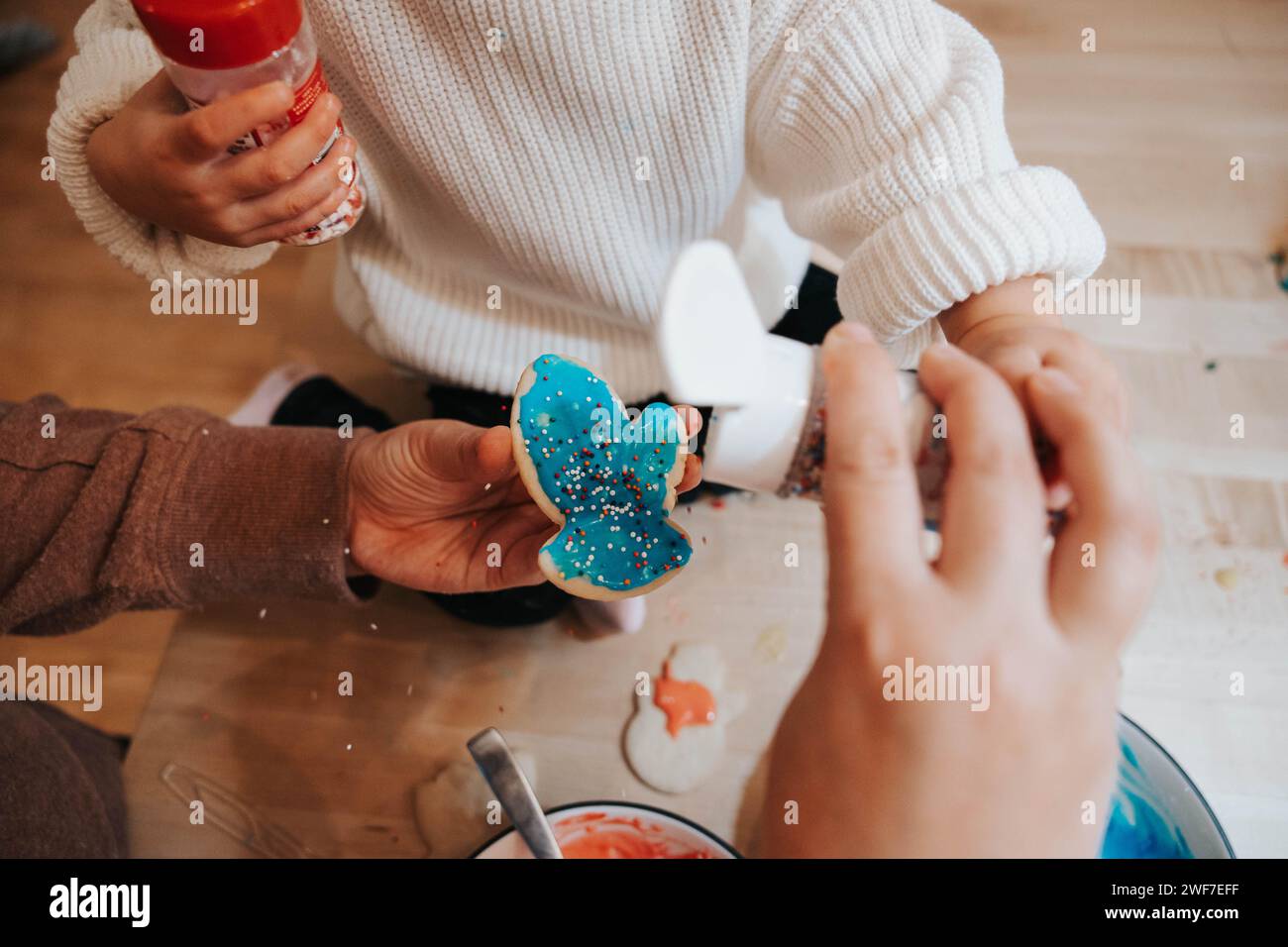 Mom and daughter sprinkle joy on cookies, kitchen delight Stock Photo ...