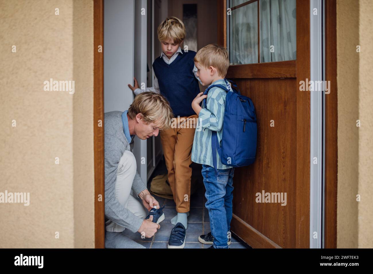 Children getting ready for school, putting on shoes, getting dressed. Father taking them to ...