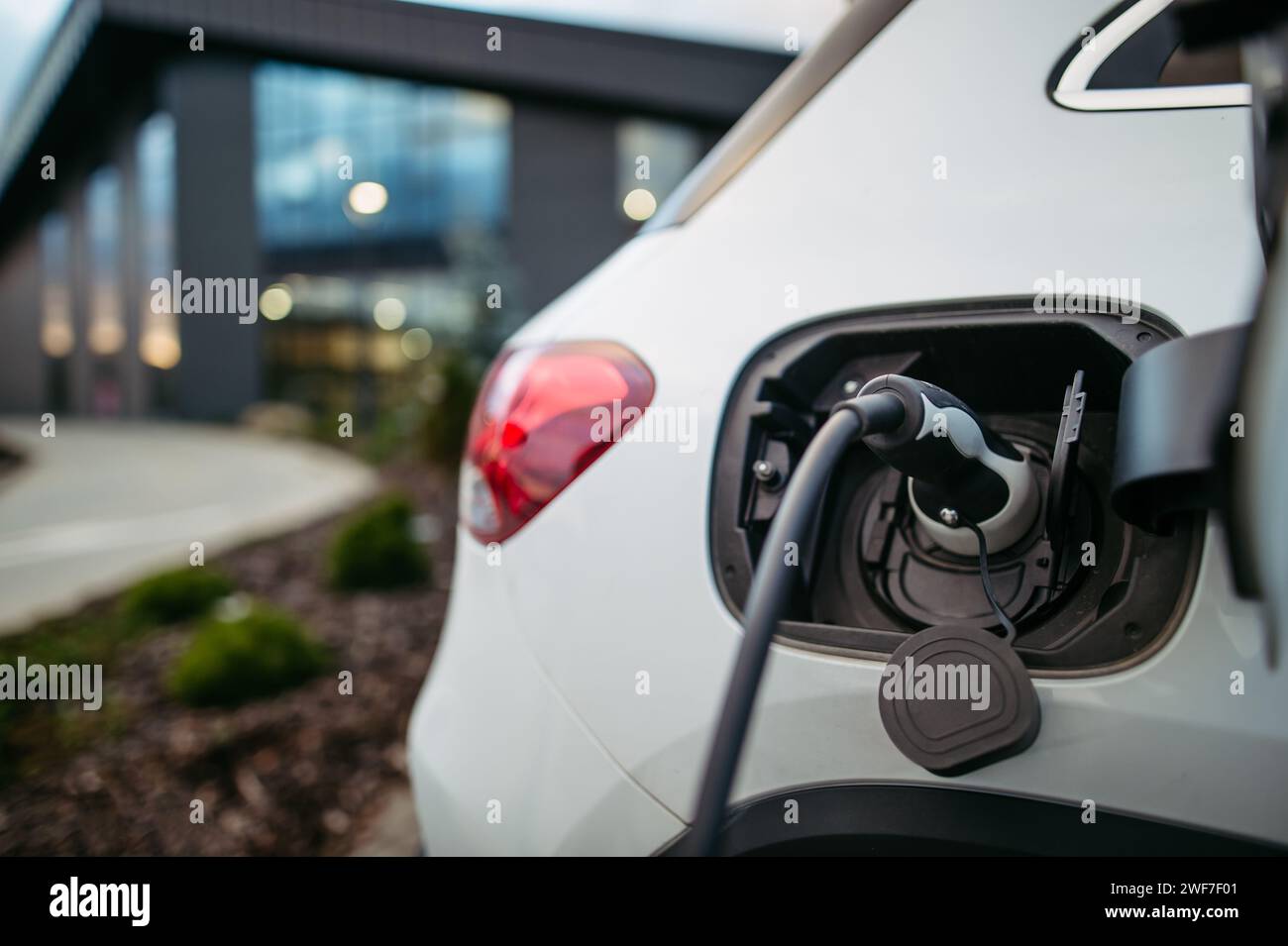 Close up electric car charging in front of office building. Charging at ...