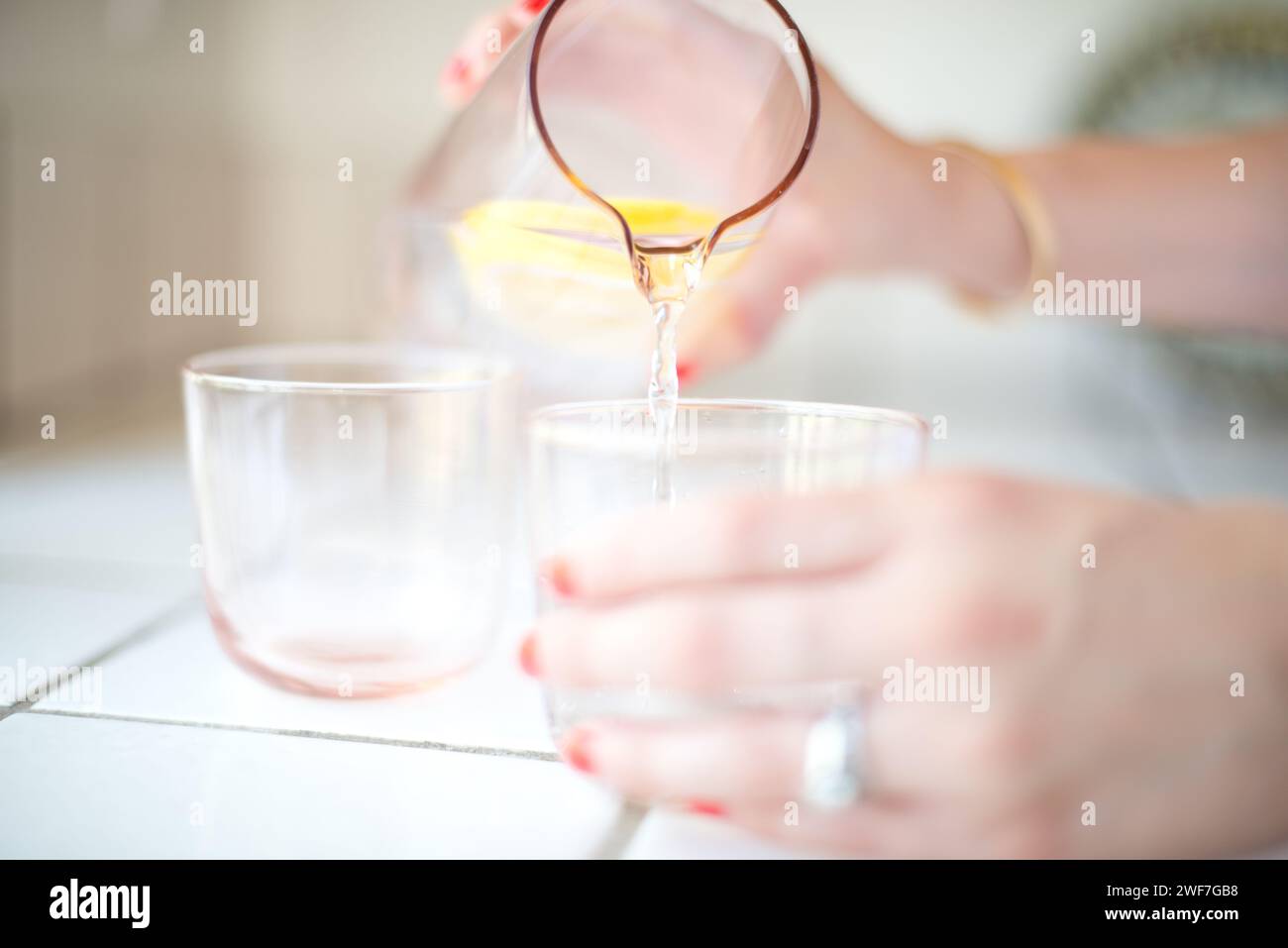 Woman pouring liquid cup hi-res stock photography and images - Alamy