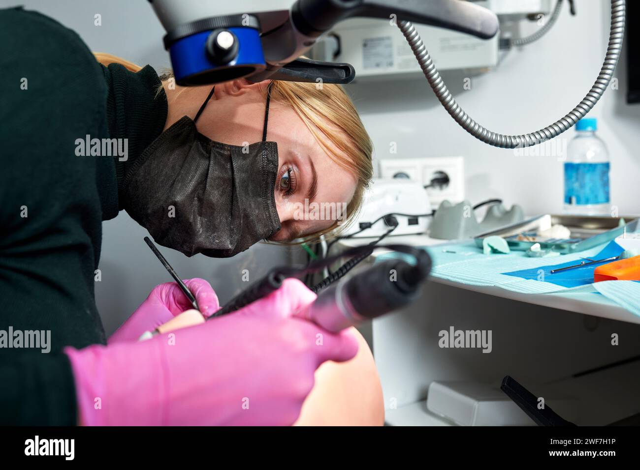 Close-up of female dentist who is learning to treat teeth on human head ...