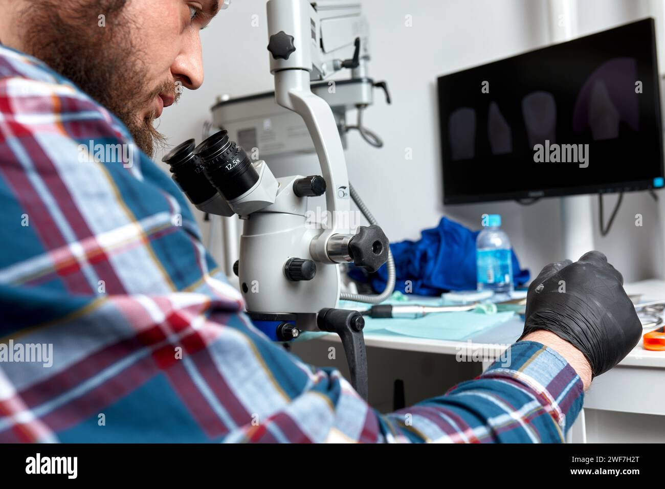 Male dentist uses dental microscope in treating teeth. Stomatology ...
