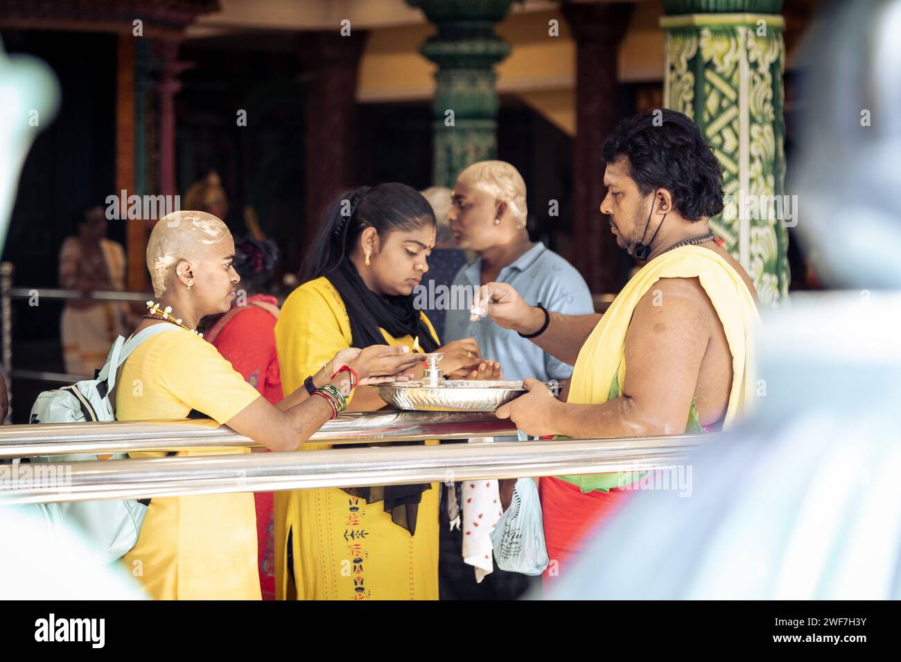 Two hindu women receiving a blessing from priest at Batu Caves Stock ...